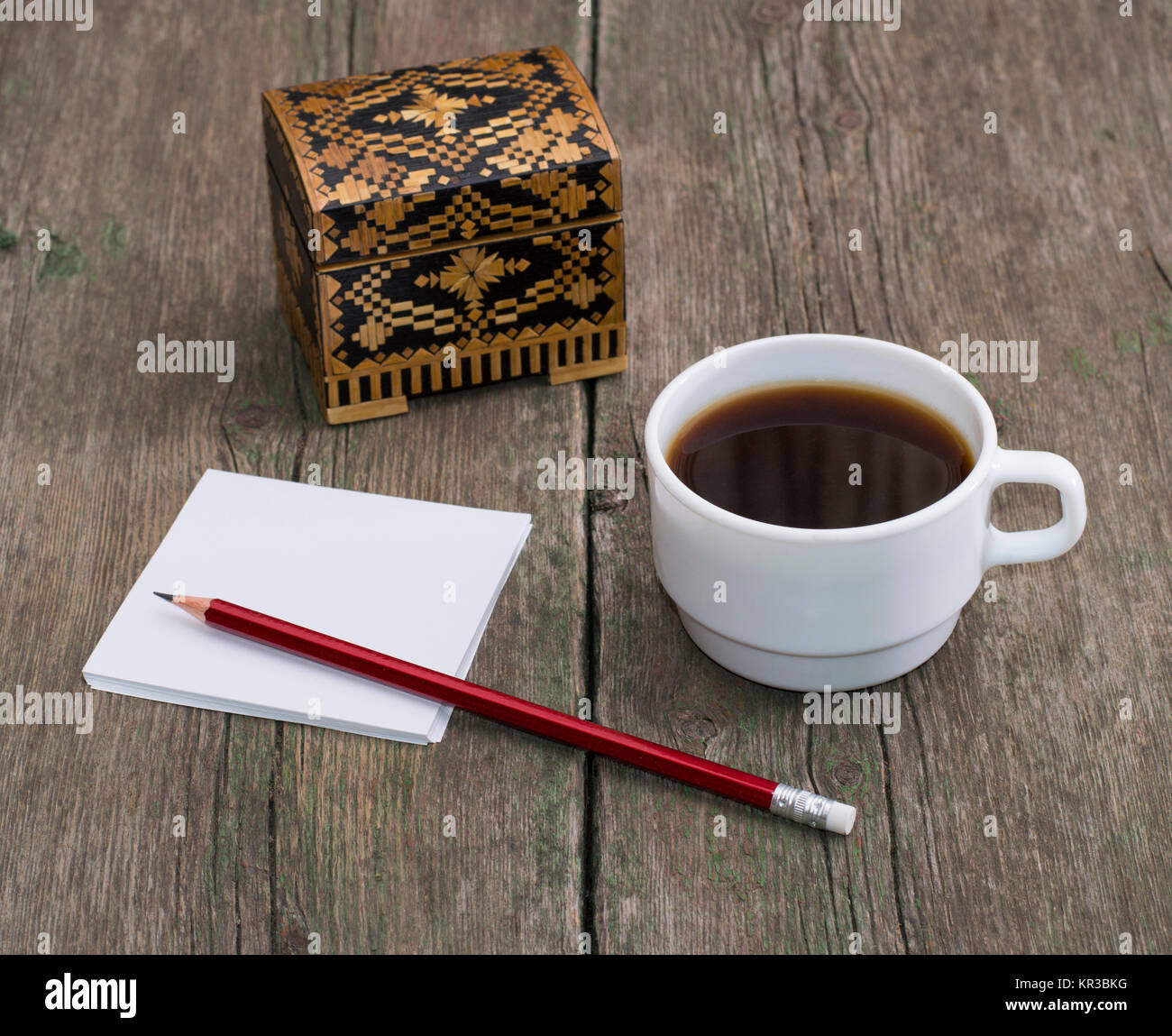 casket, coffee in a white cup and paper with a pencil, a still life on ...
