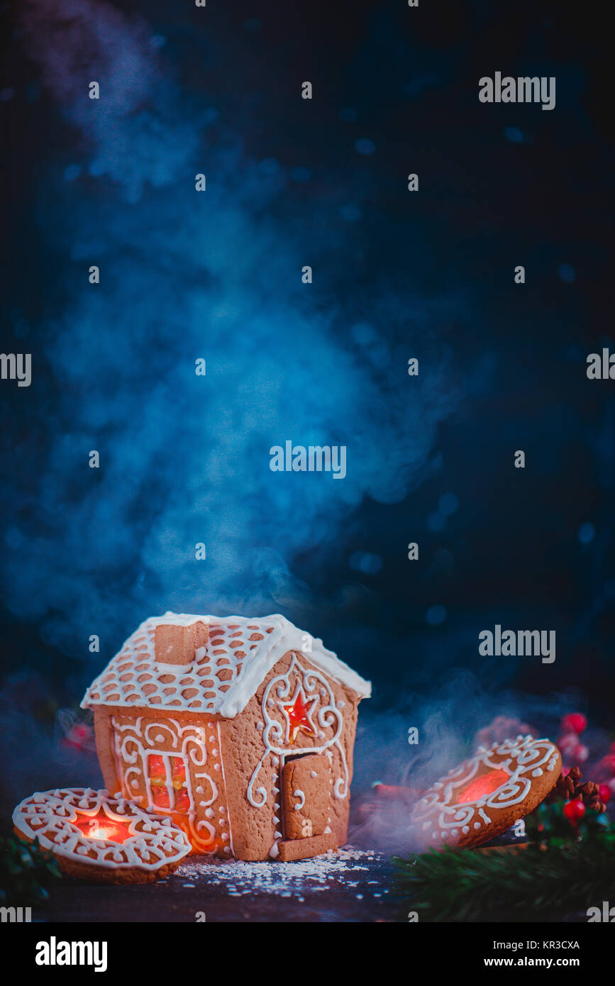 Gingerbread house with shining windows and rising smoke from a chimney ...