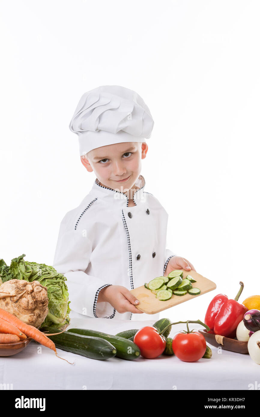 One little boy as chef cook making salad, cooking with vegetables ...