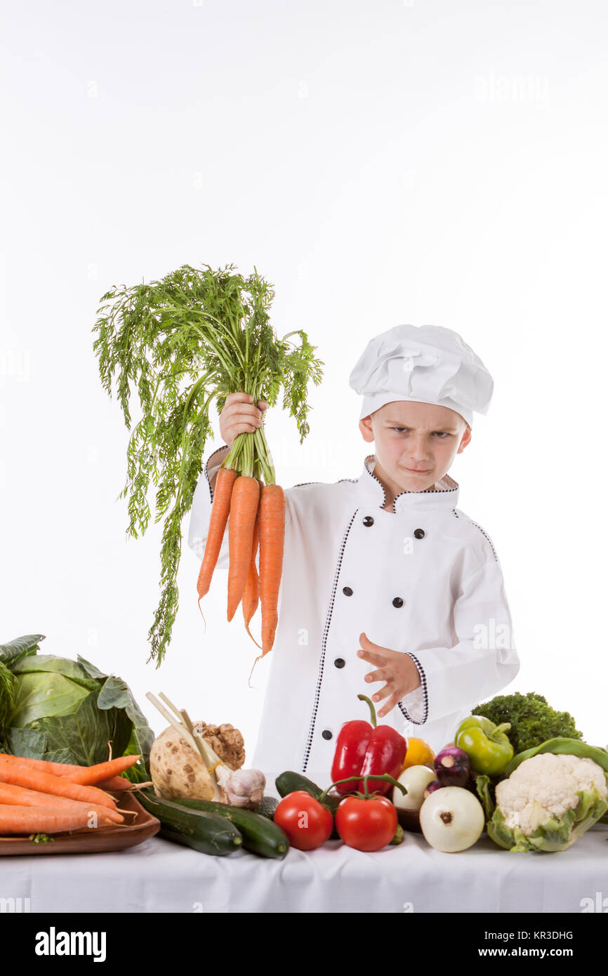 One little boy as chef cook making salad, cooking with vegetables ...