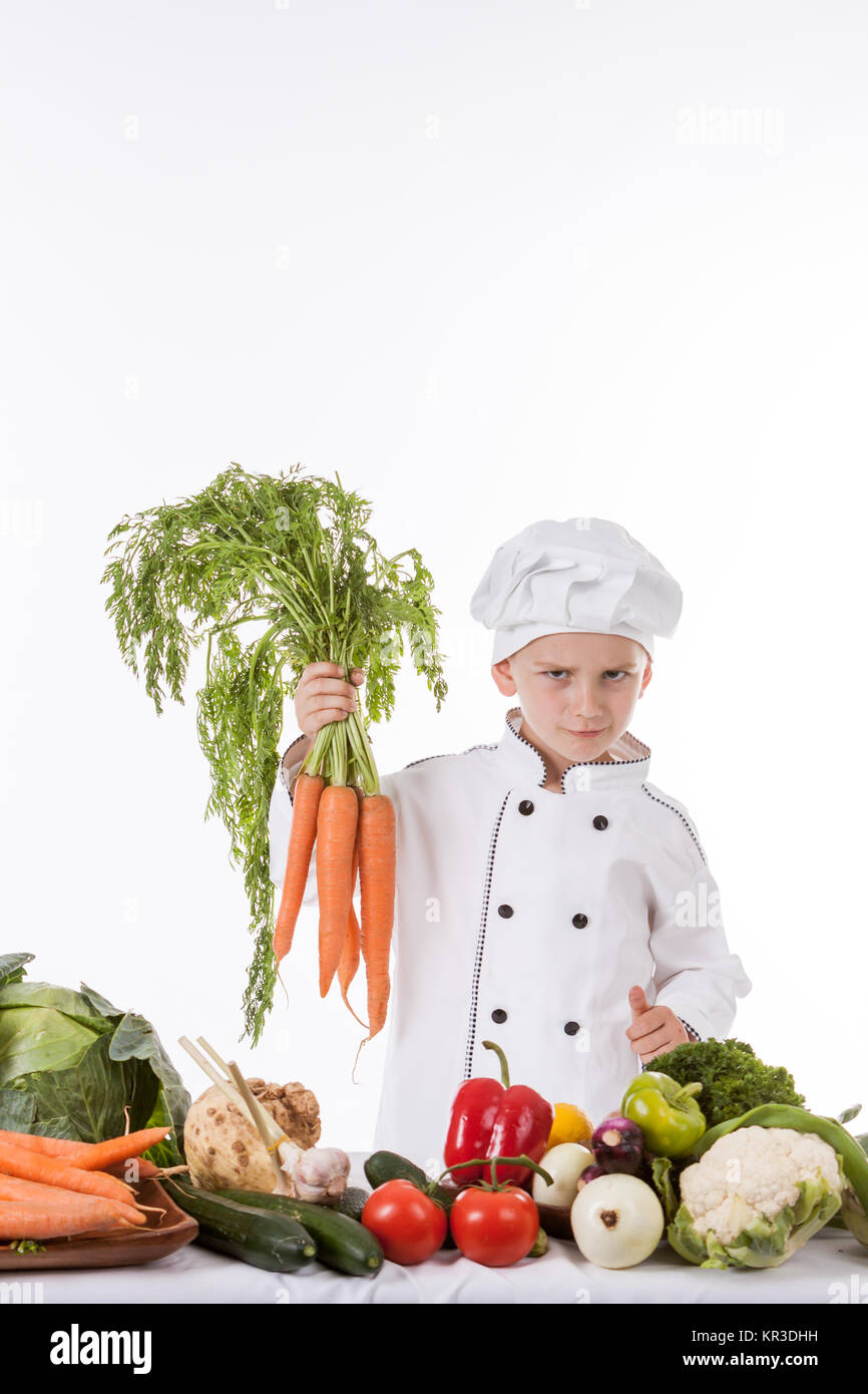 One little boy as chef cook making salad, cooking with vegetables ...