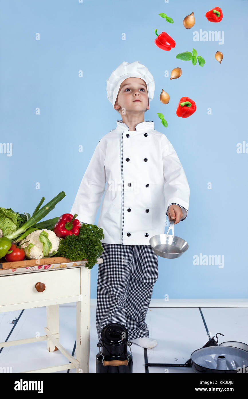 One little boy as chef cook making salad, cooking with vegetable Stock ...