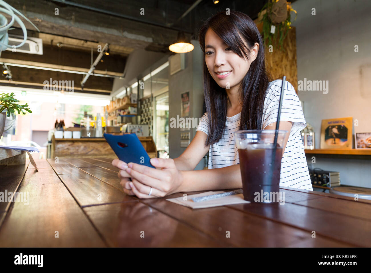 Woman using cellphone in coffee shop Stock Photo - Alamy