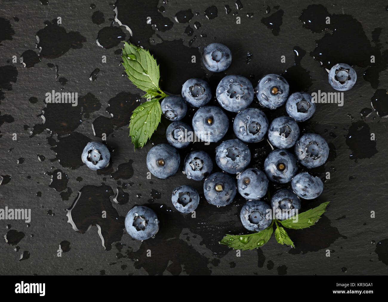 Close up fresh washed blueberry berries with water drops and green mint ...