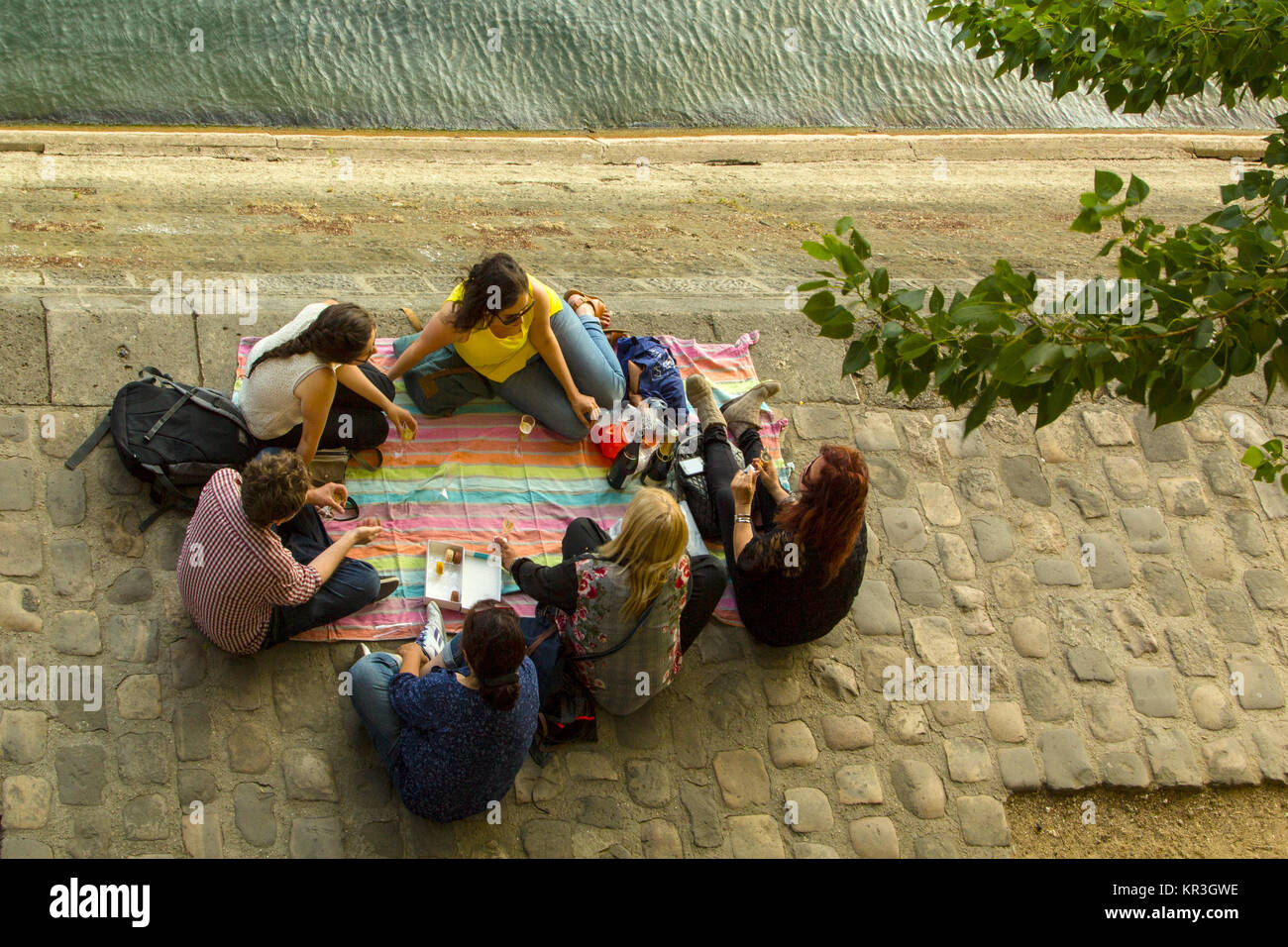 Many young people relaxing at summer afternoon in île Saint-Louis on the banks of river Seine in ...