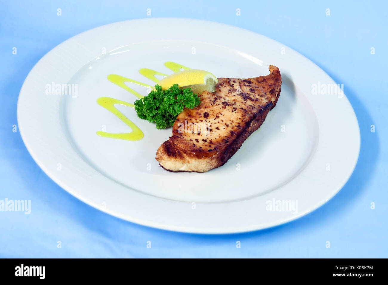 Modern food on a white plate and blue background Stock Photo - Alamy