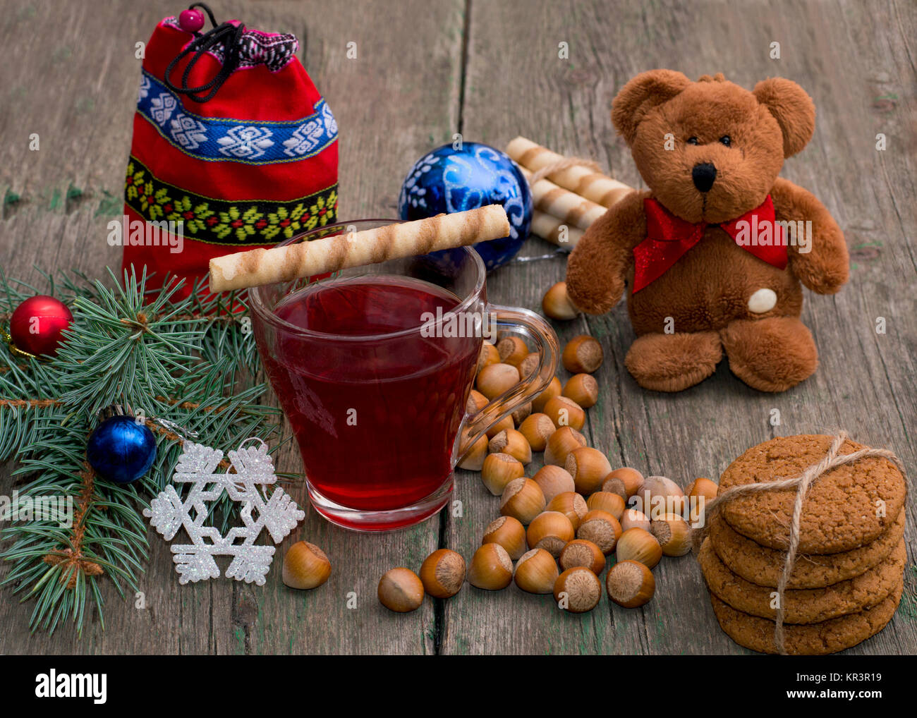 fir-tree branch, tea, bear, baking, bag and nuts, on a wooden table ...