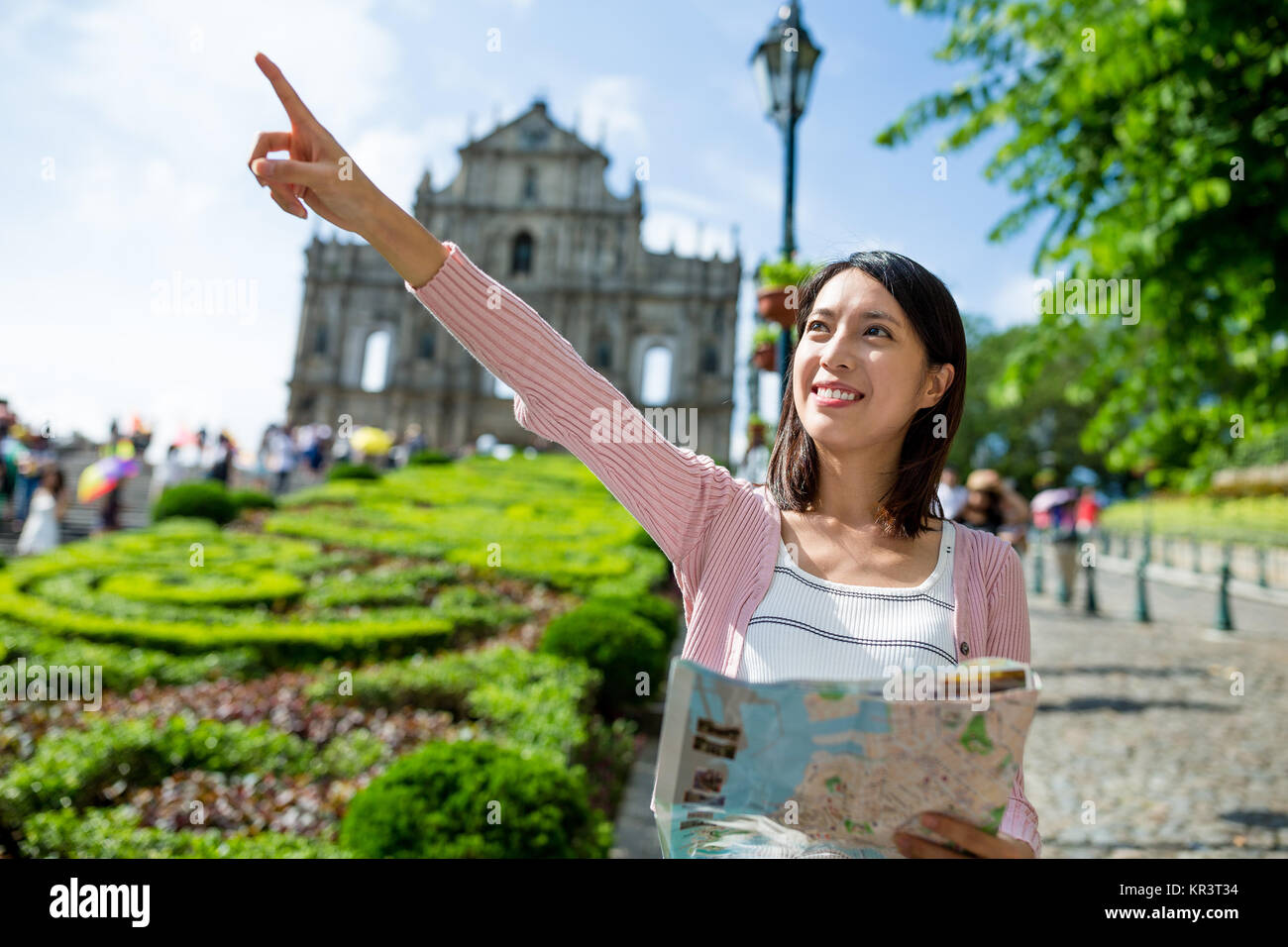 Woman holding city map and finger pointing far away Stock Photo - Alamy