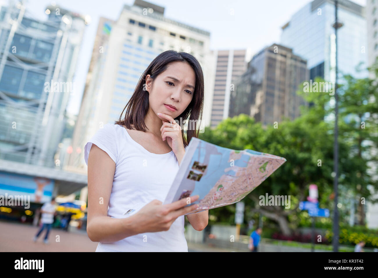 Woman use paper map to find location Stock Photo - Alamy
