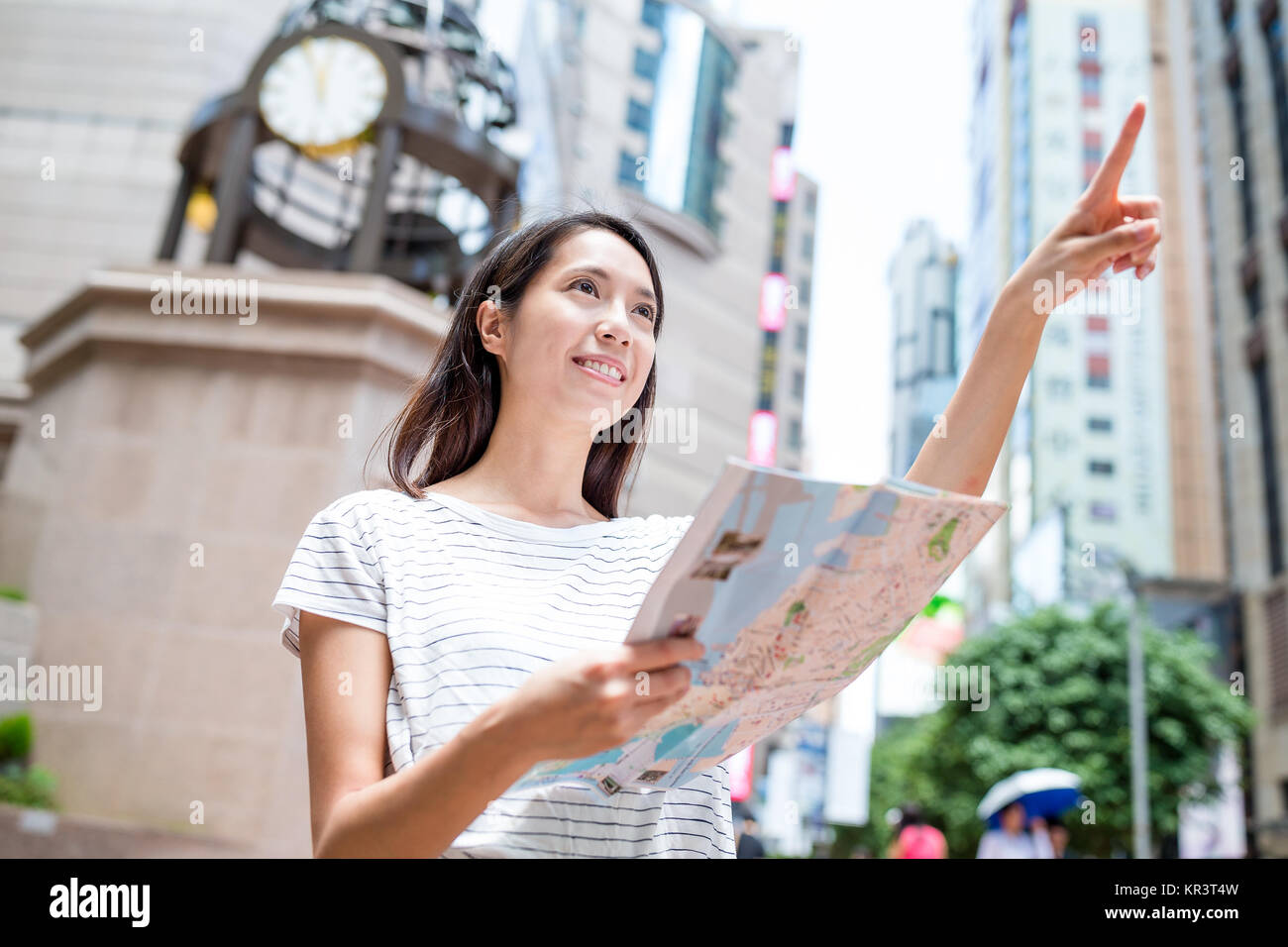 Young woman use of city map and finger pointing far away Stock Photo ...
