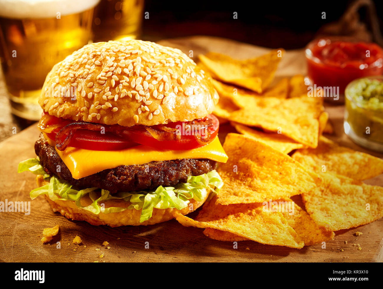 Large sesame seed bun cheeseburger topped with tomatoes, onions and ...