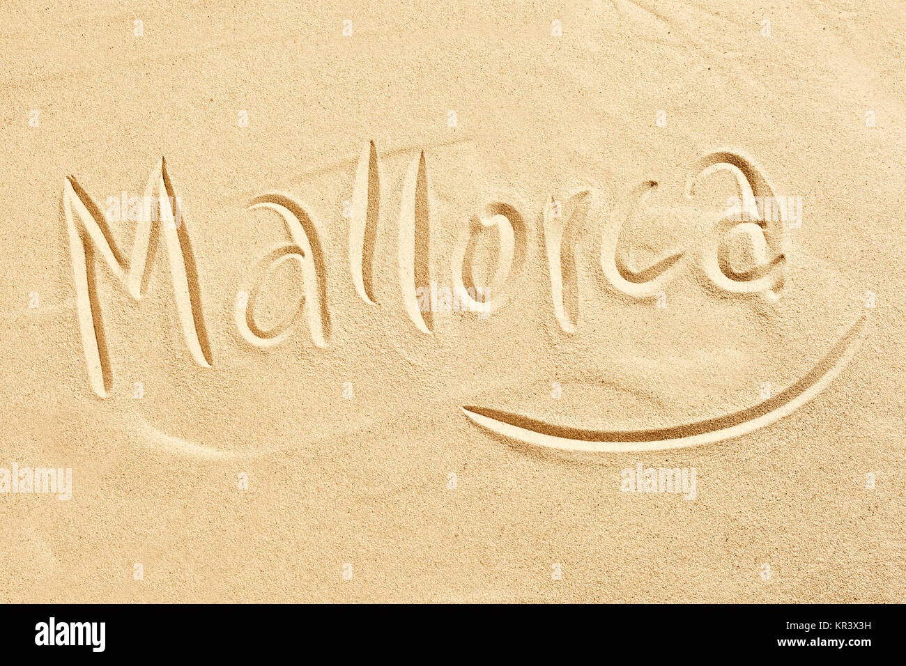 Mallorca handwritten in golden beach sand conceptual of seaside ...
