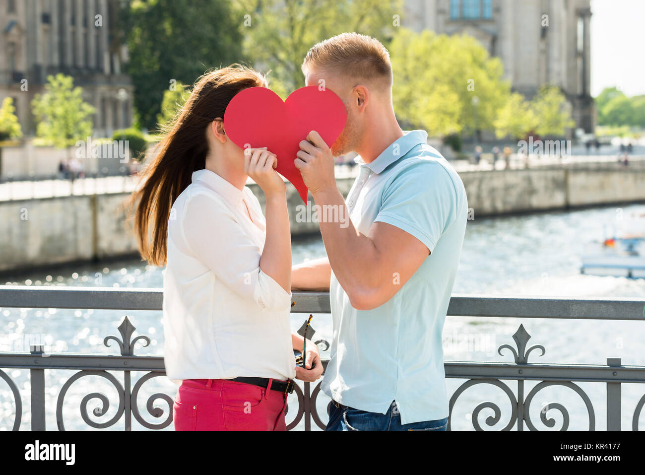 Couple Kissing Behind Heart Shape Stock Photo - Alamy