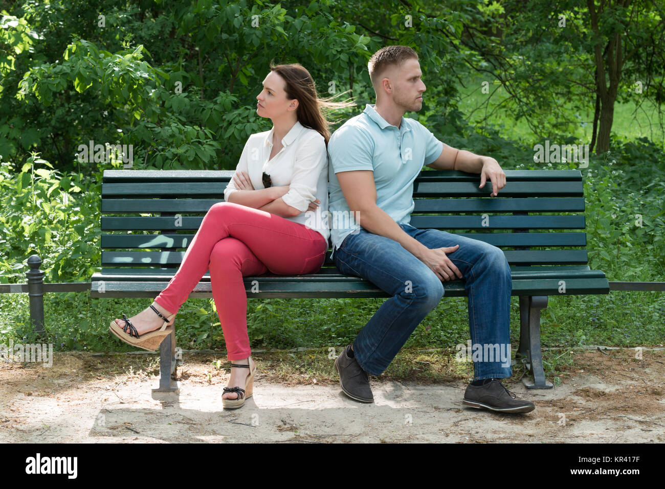 Couple Sitting Back To Back On Bench Stock Photo - Alamy