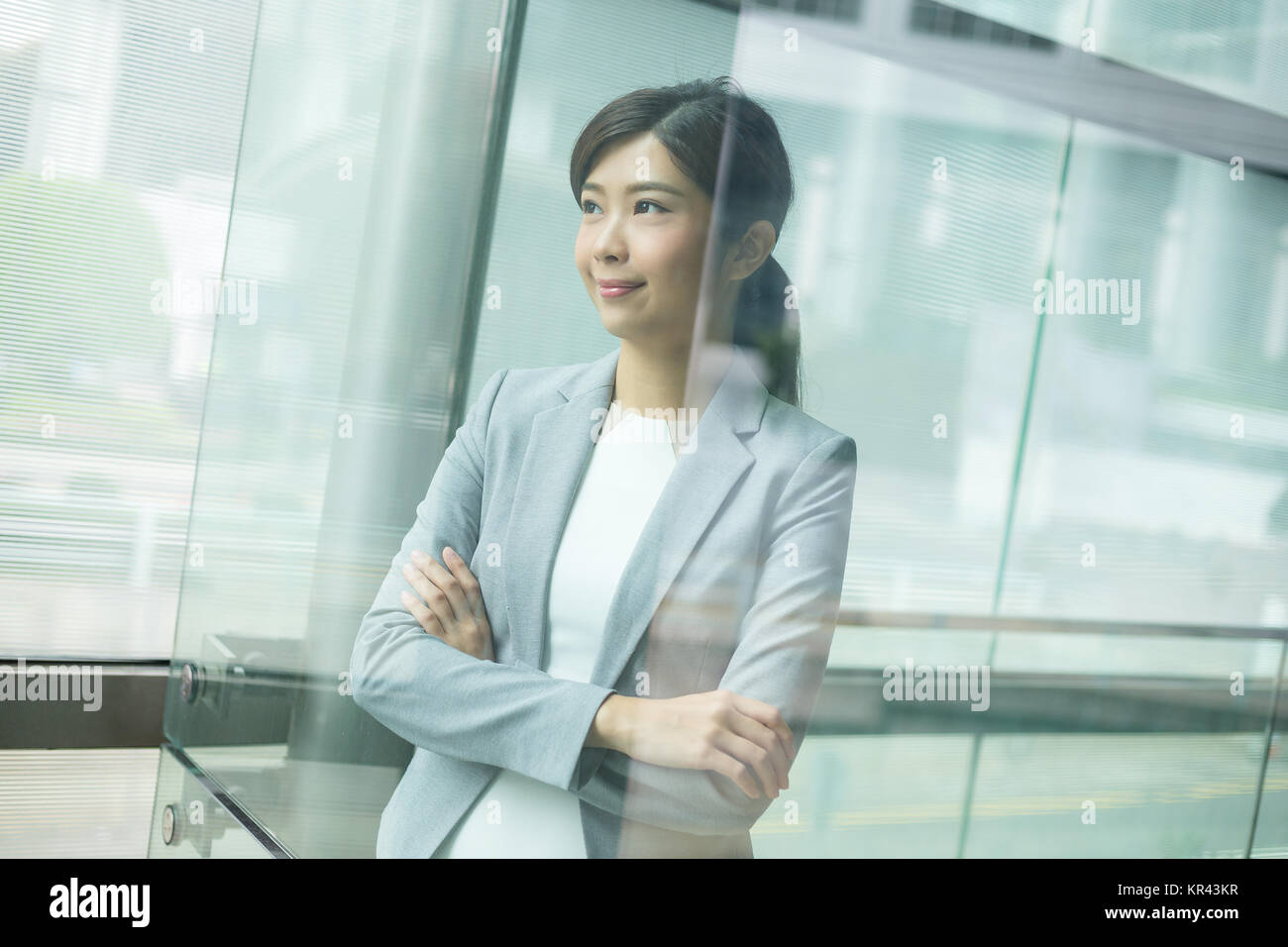 Business woman standing inside office Stock Photo - Alamy