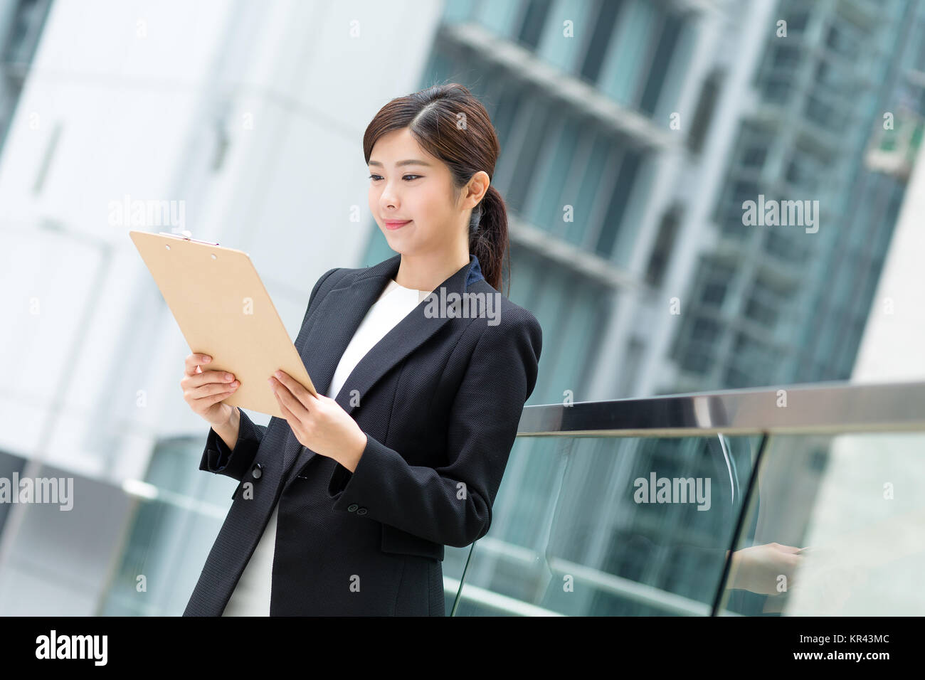 Businesswoman read on clipboard Stock Photo - Alamy