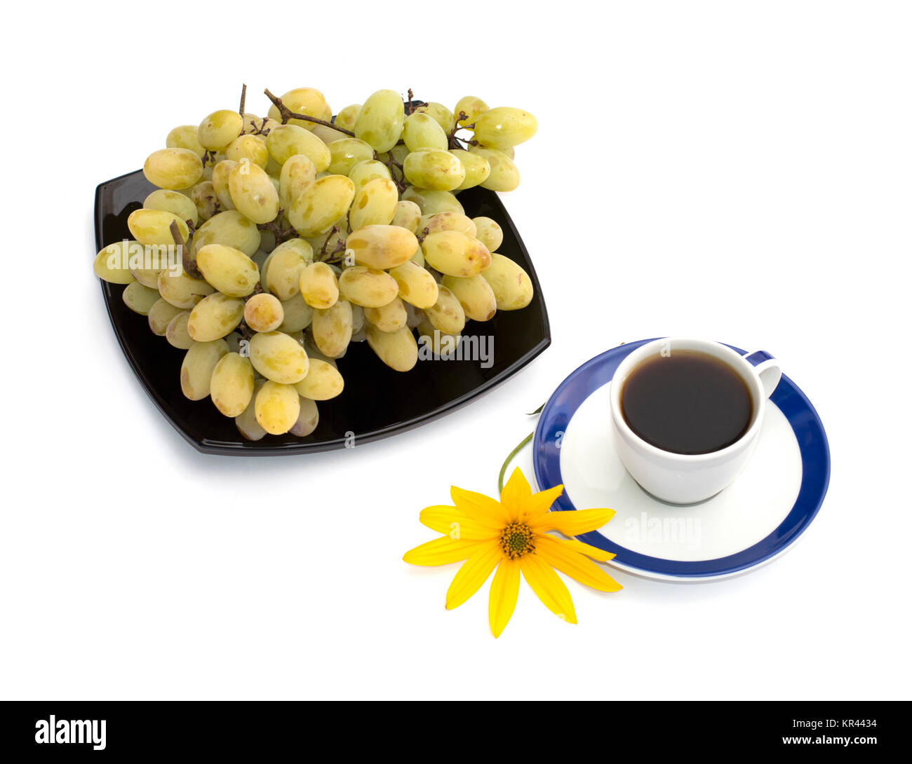 cup of coffee, yellow flower and plate with grapes, the isolated image ...