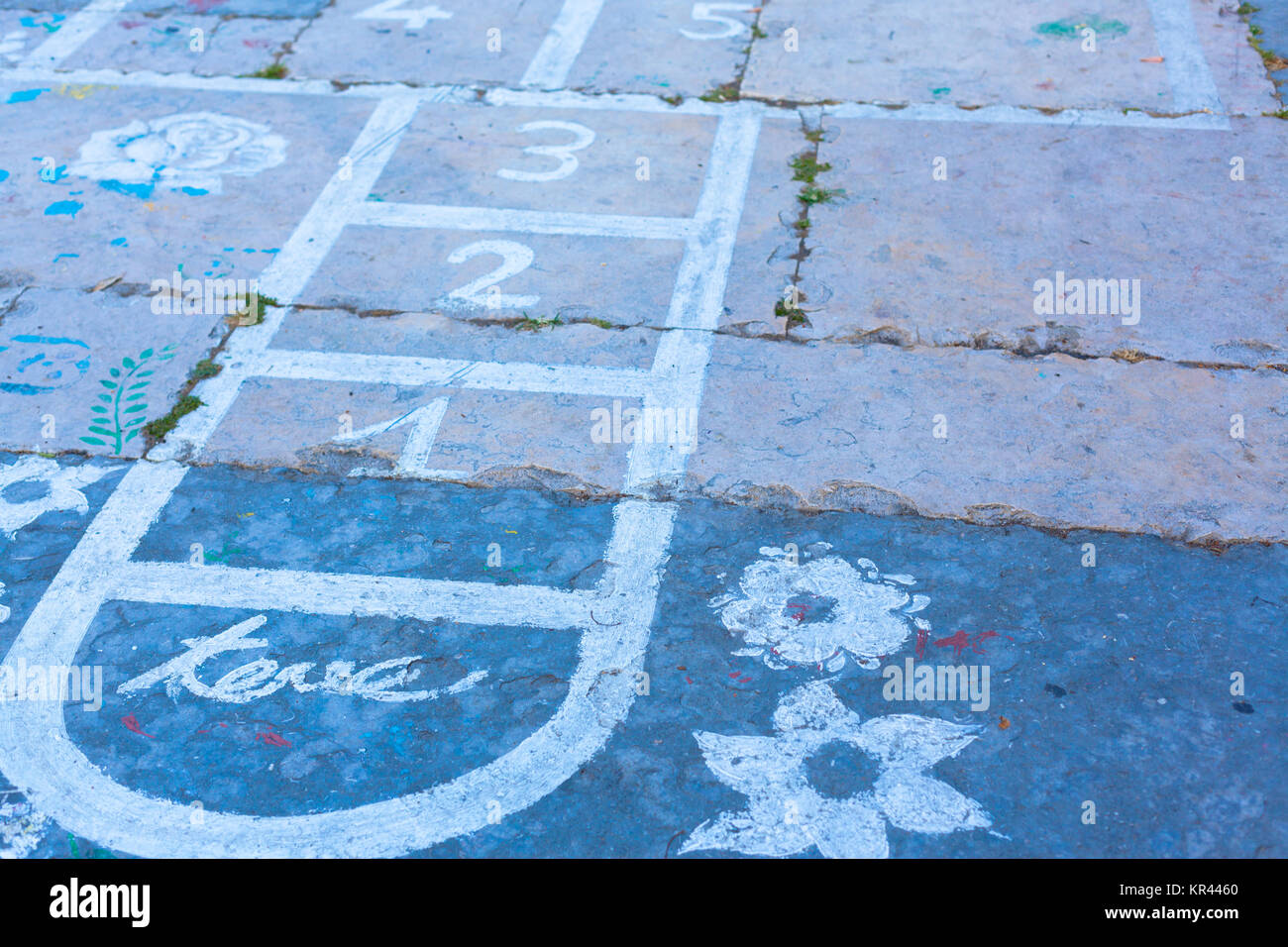 Hopscotch on an asphalt floor with chalk drawings of numbers and ...