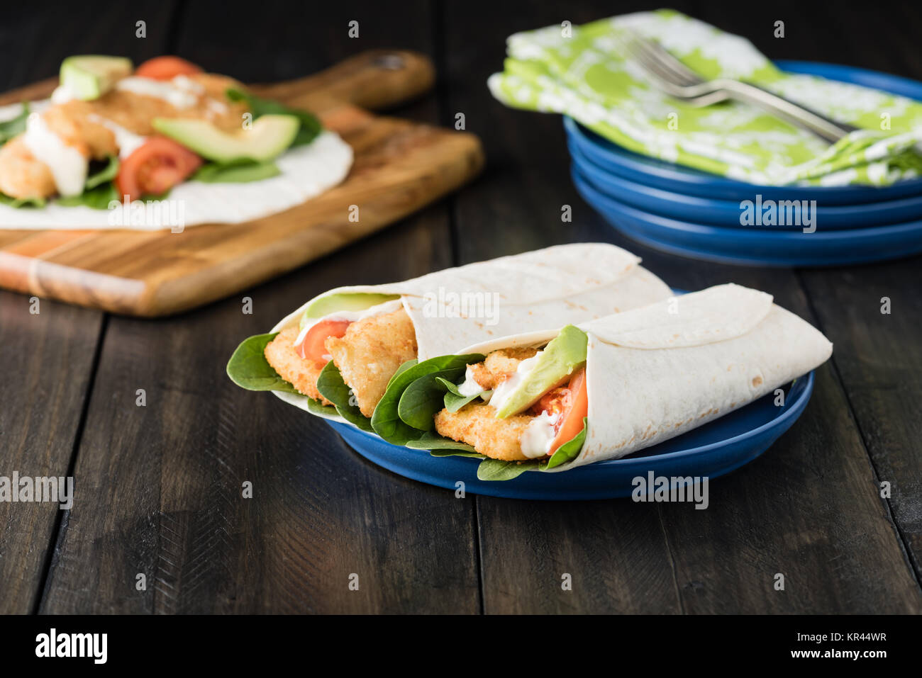 Crumbed fish fillet burrito with avocado and tomato Stock Photo - Alamy