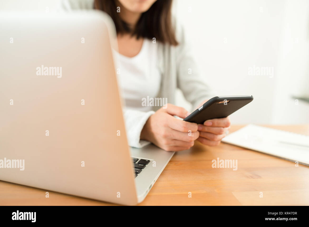 Woman using mobile phone on her working desk Stock Photo - Alamy