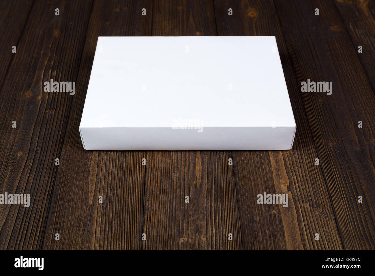 Empty white gift box or tray for mock up on dark wooden table with copy ...
