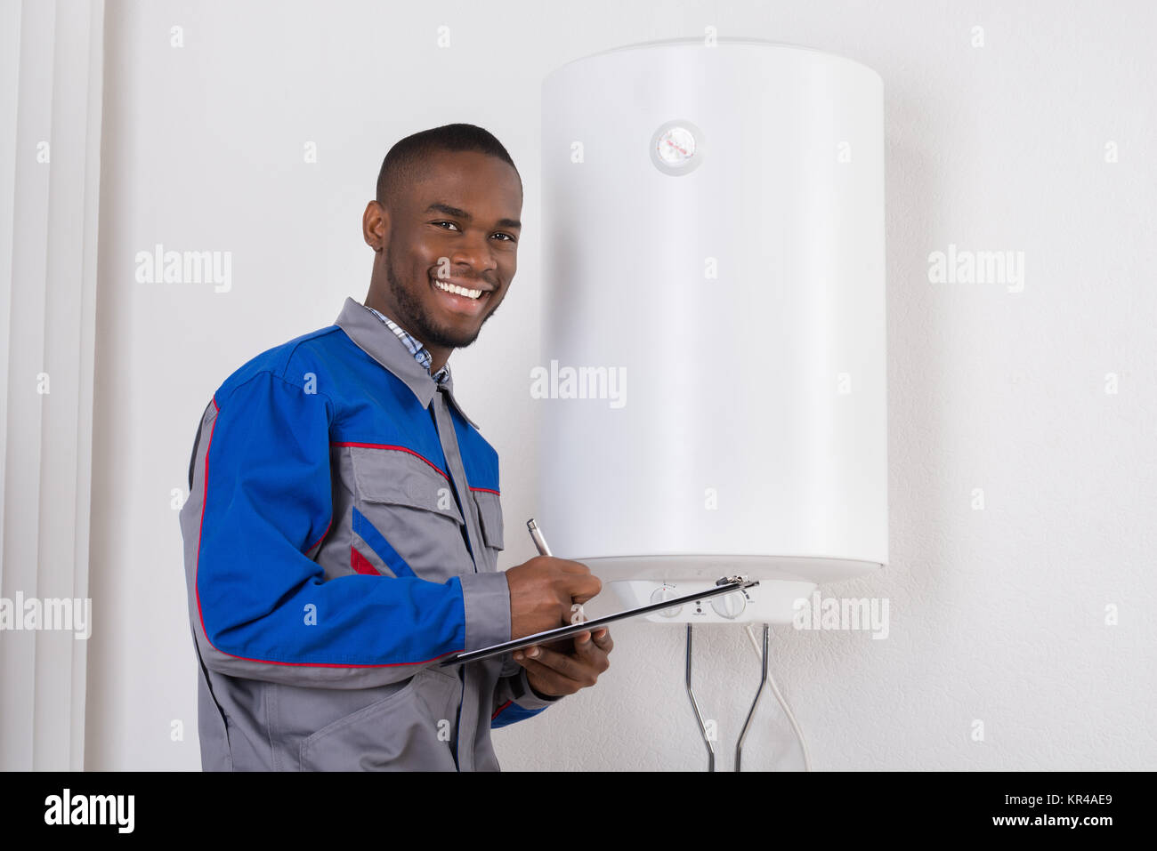 Plumber Looking At Electric Boiler Stock Photo - Alamy