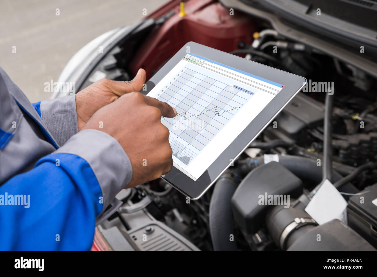 Mechanic With Digital Tablet While Examining Car Stock Photo - Alamy