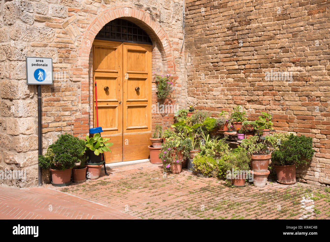 Wooden door with flower pots in the medieval tuscan Town San Gimignano ...