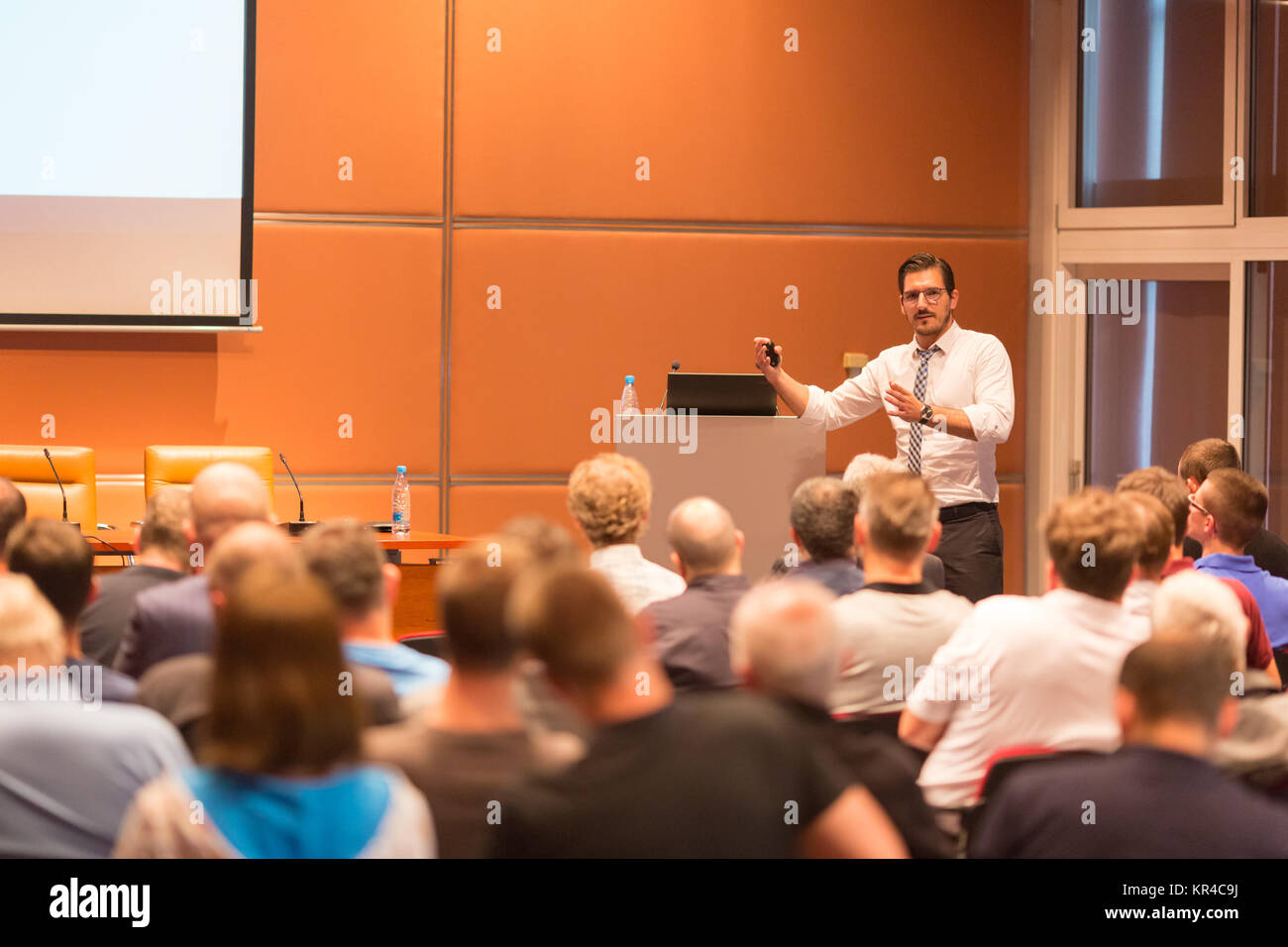 Business speaker giving a talk in conference hall Stock Photo - Alamy