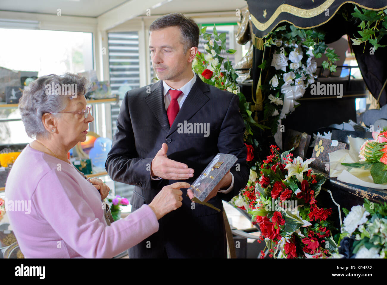 Funeral director showing woman a memorial plaque Stock Photo - Alamy