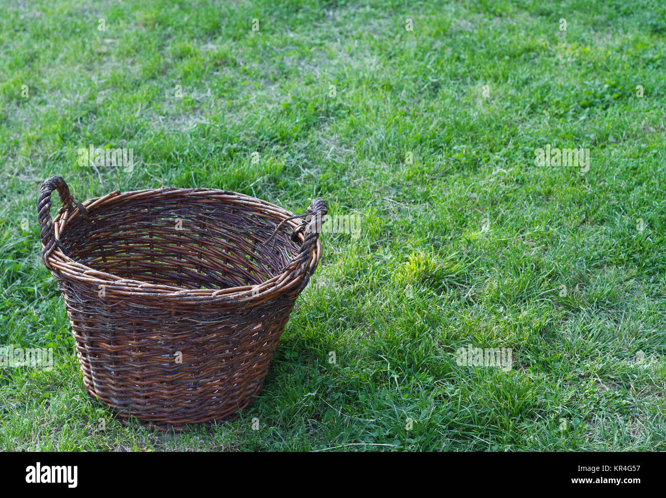 one wooden empty rustic basket on a green field Stock Photo - Alamy