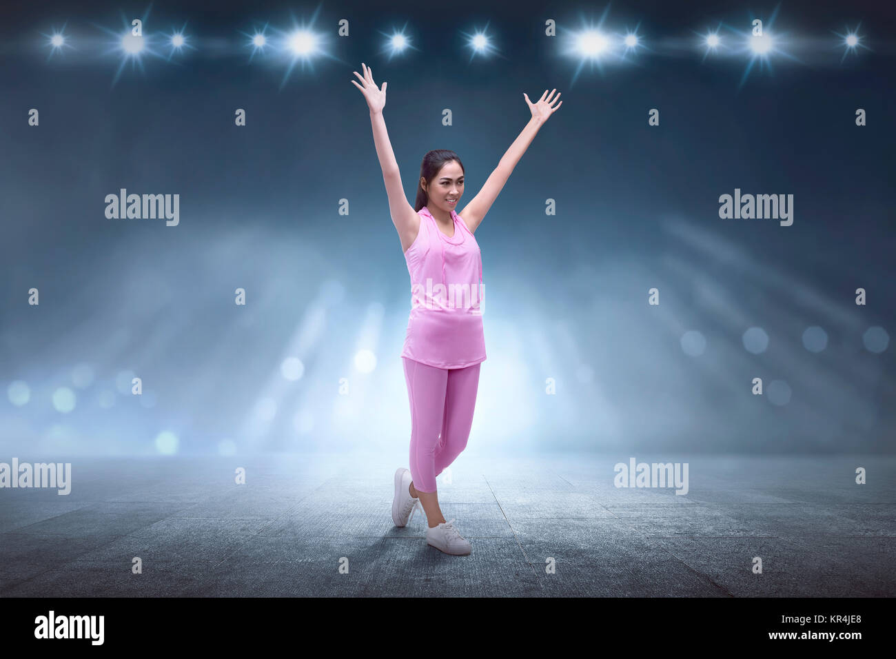 Excited asian runner woman after exercising with spotlight background ...