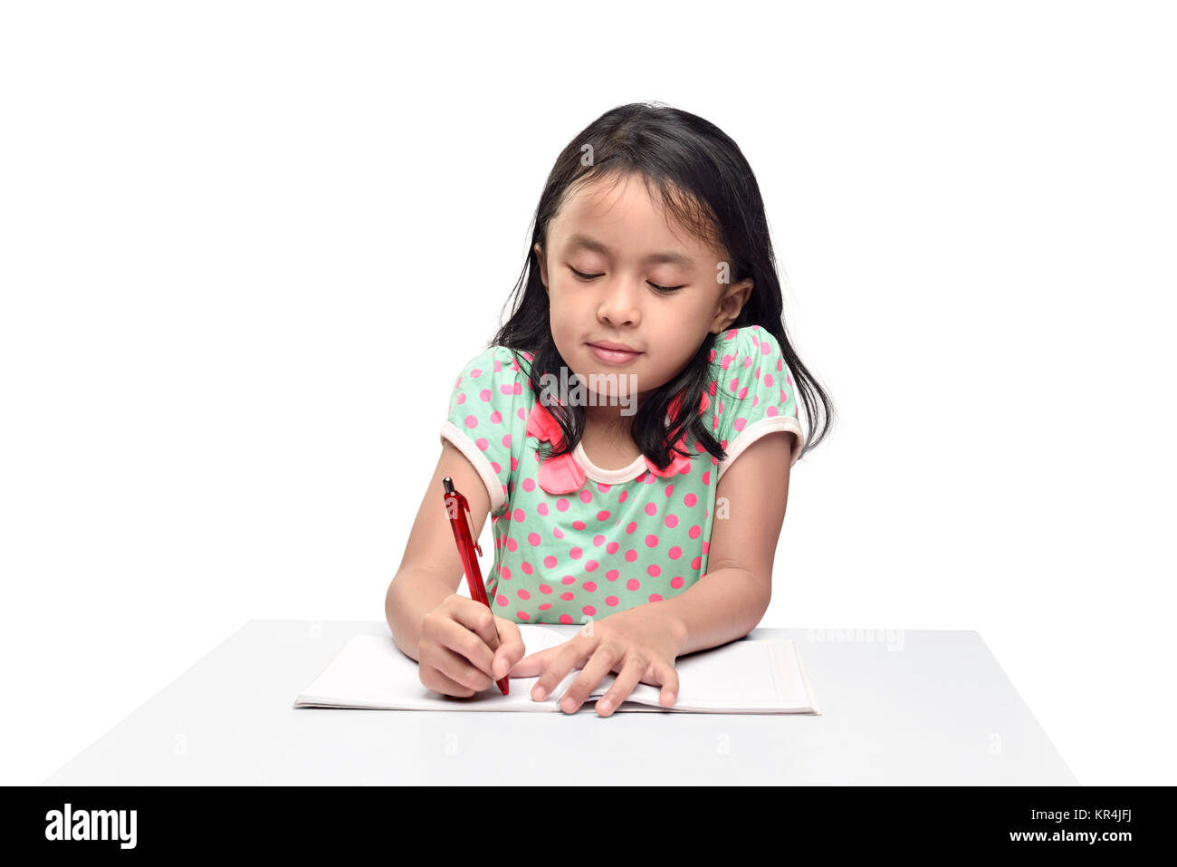 Portrait of asian little girl with pen writing in the book posing ...