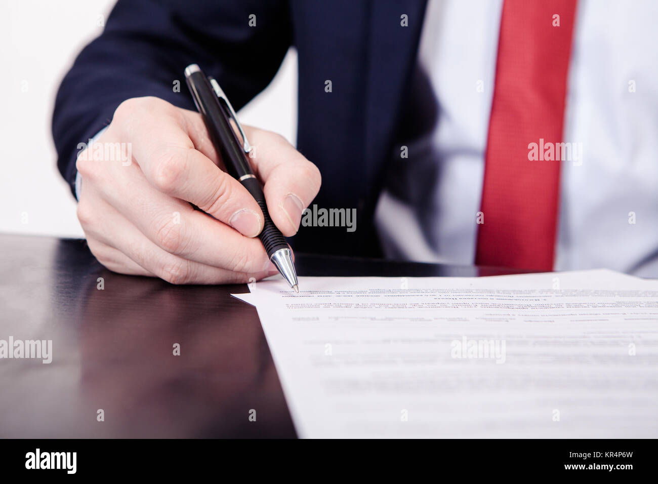 A hand holding a fountain pen and about to sign a letter. Styling and ...