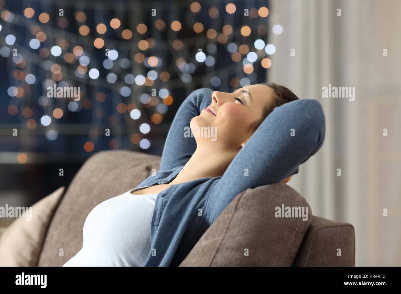 Side view portrait of a relaxed happy woman resting sitting on a couch ...