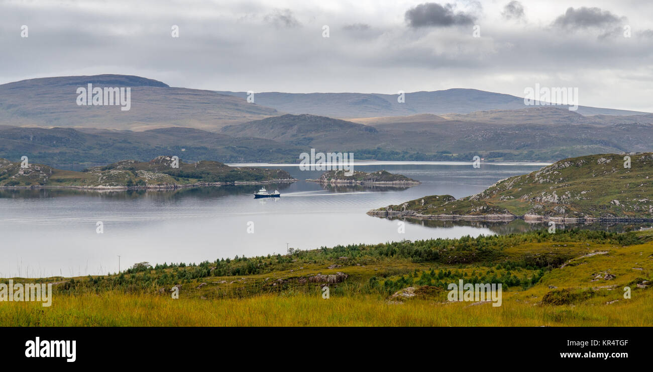 A fishing boat passes between rocky islands and peninsulas in Loch ...