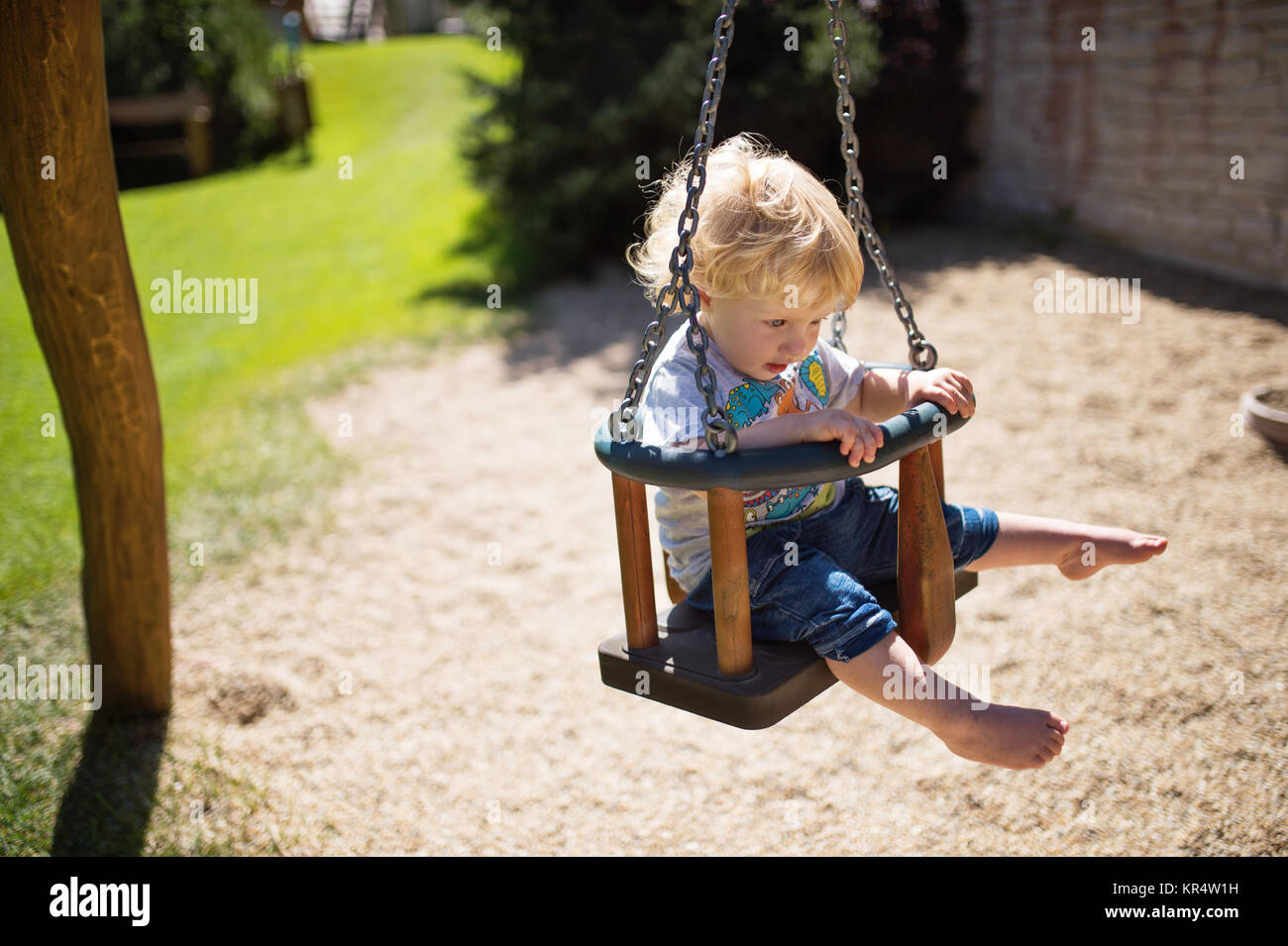 Little boy on the swing at the playground Stock Photo - Alamy