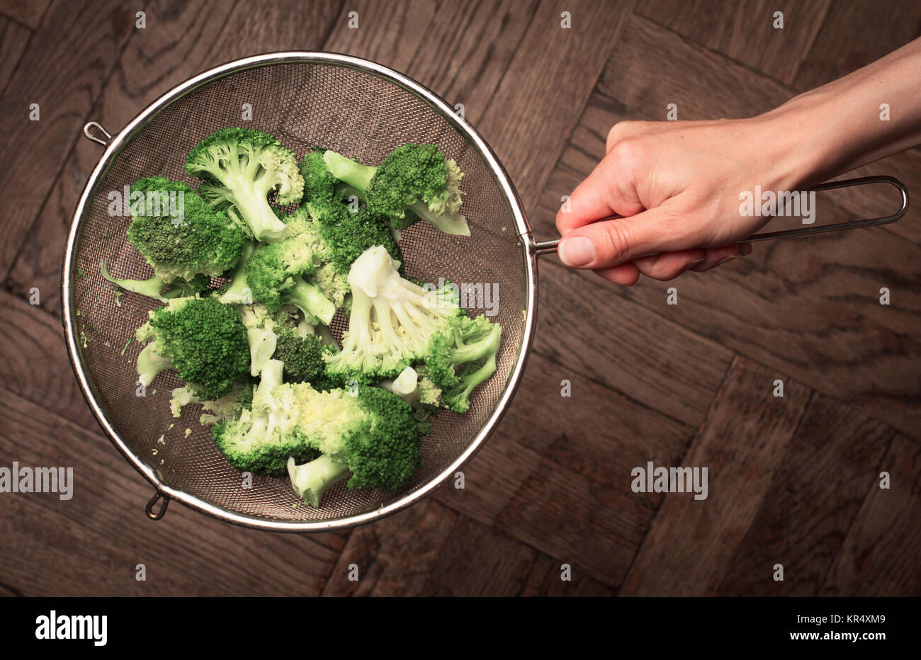 Top view of a hand holding a strainer with cut broccoli Stock Photo - Alamy