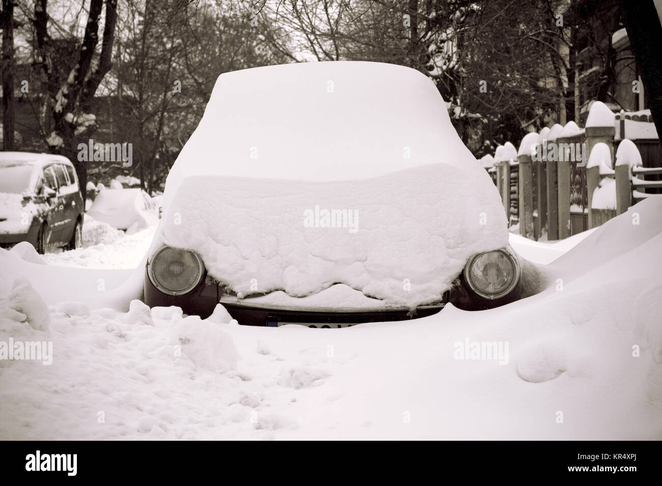 Car stuck in snow on a street with only headlights showing Stock Photo ...