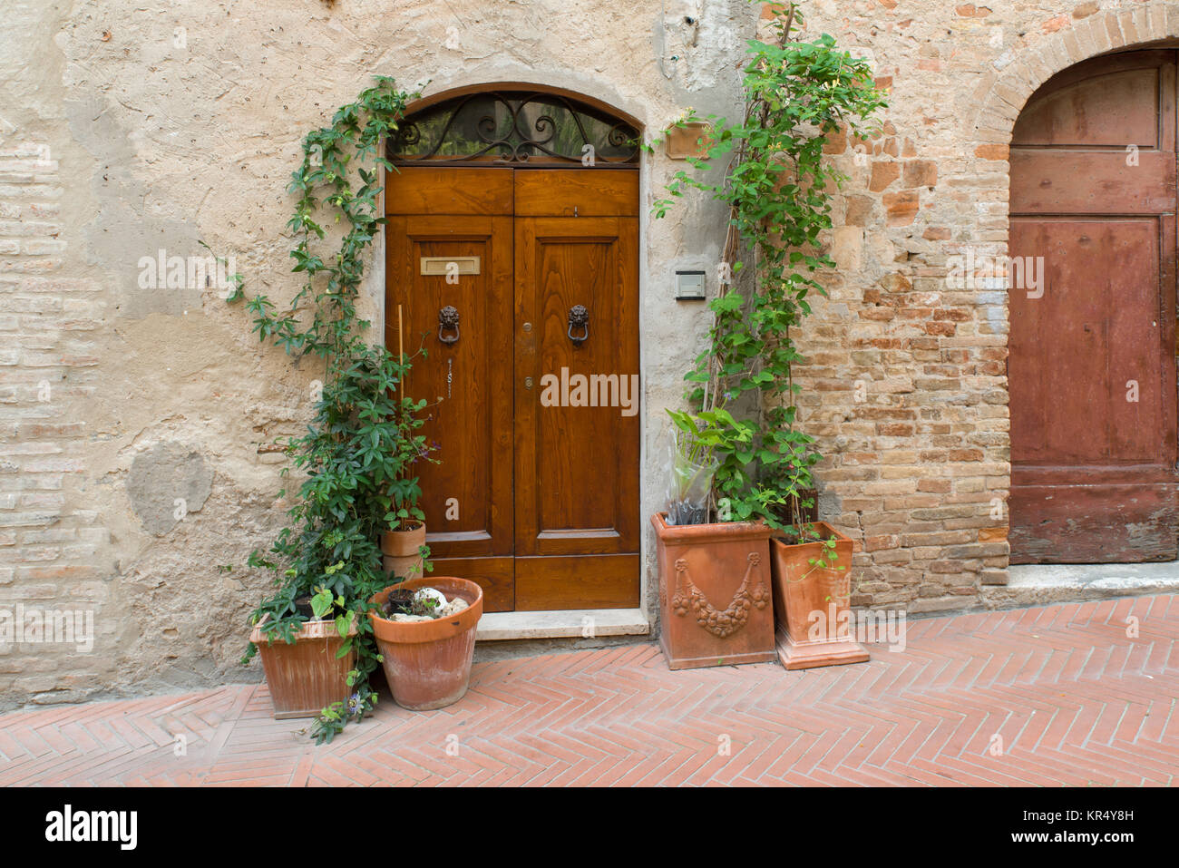 Wooden door with flower pots in the medieval tuscan Town San Gimignano ...