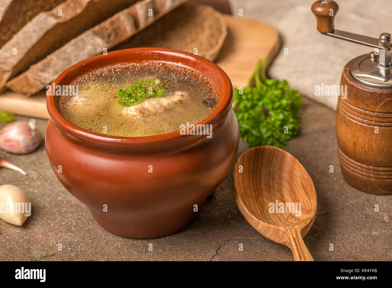 fresh transparent fish soup with sturgeon, potatoes in clay pot ...