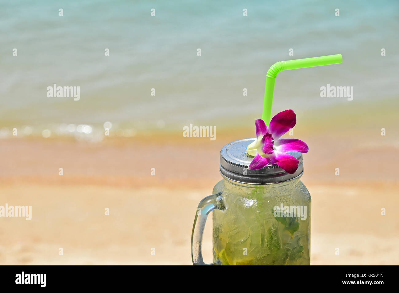 Big glass of mojito with orchid flower on beach Stock Photo - Alamy