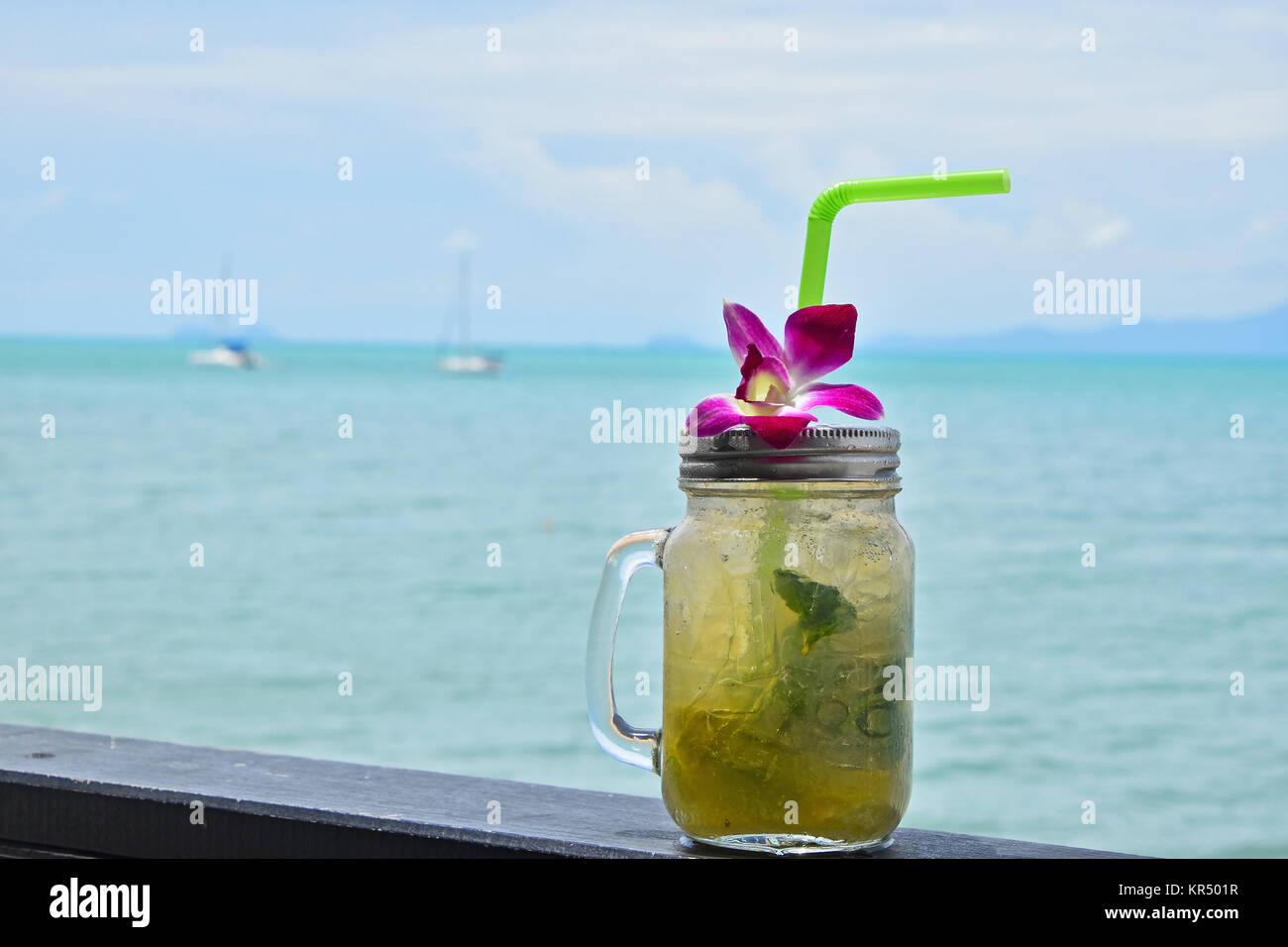 Big glass of mojito with orchid flower on beach Stock Photo - Alamy