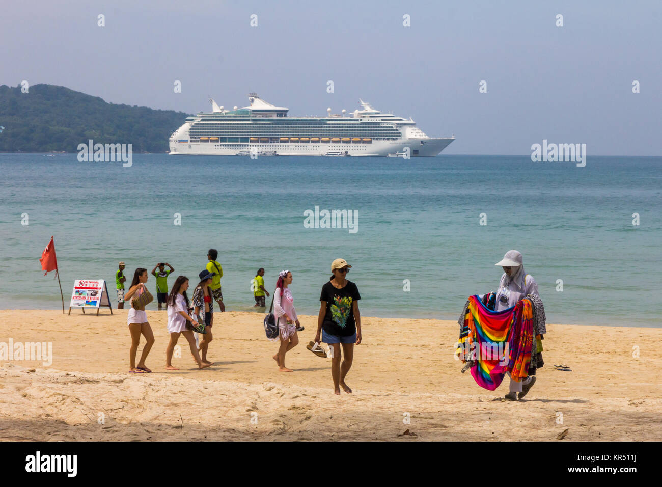 Beach vendor offering cloth to tourists on Patong beach with Royal ...