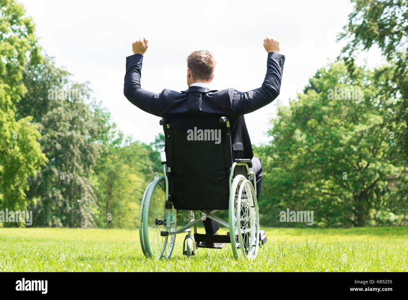 Young Disabled Man On Wheelchair With Arm Raised Stock Photo - Alamy