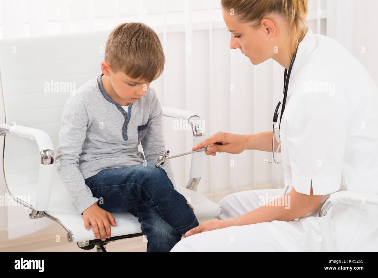 Doctor Checking Knee Reflex On Child Patient Stock Photo - Alamy