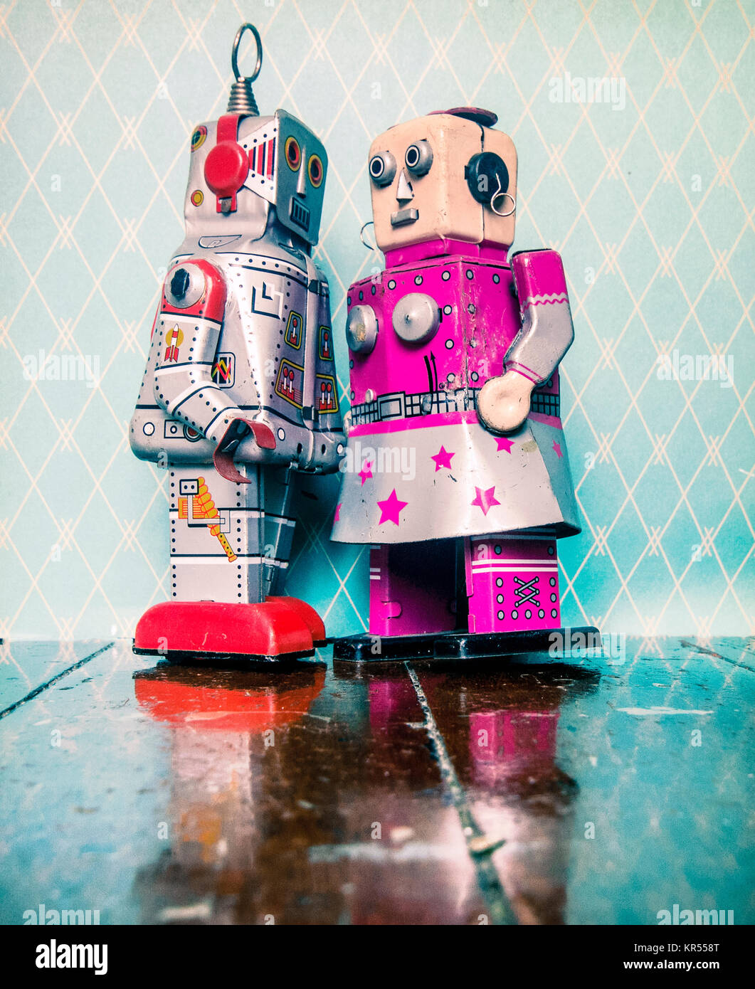 two retro robot toys in love on old wooden floor with reflection Stock ...
