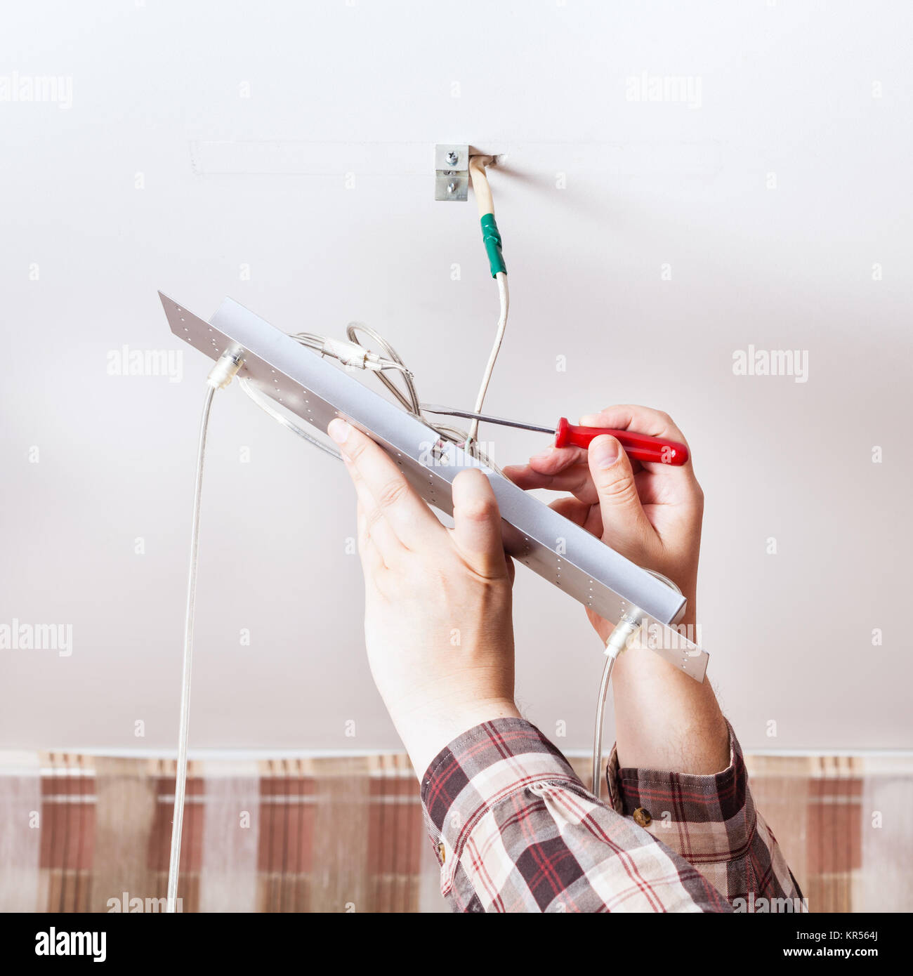 Electrician mounts wiring in ceiling lamp Stock Photo - Alamy
