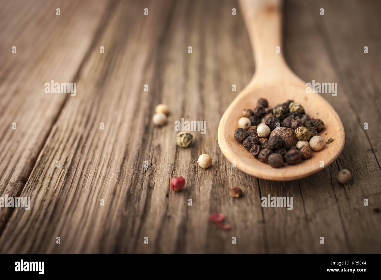 Pepper mix on the wooden spoon horizontal Stock Photo - Alamy