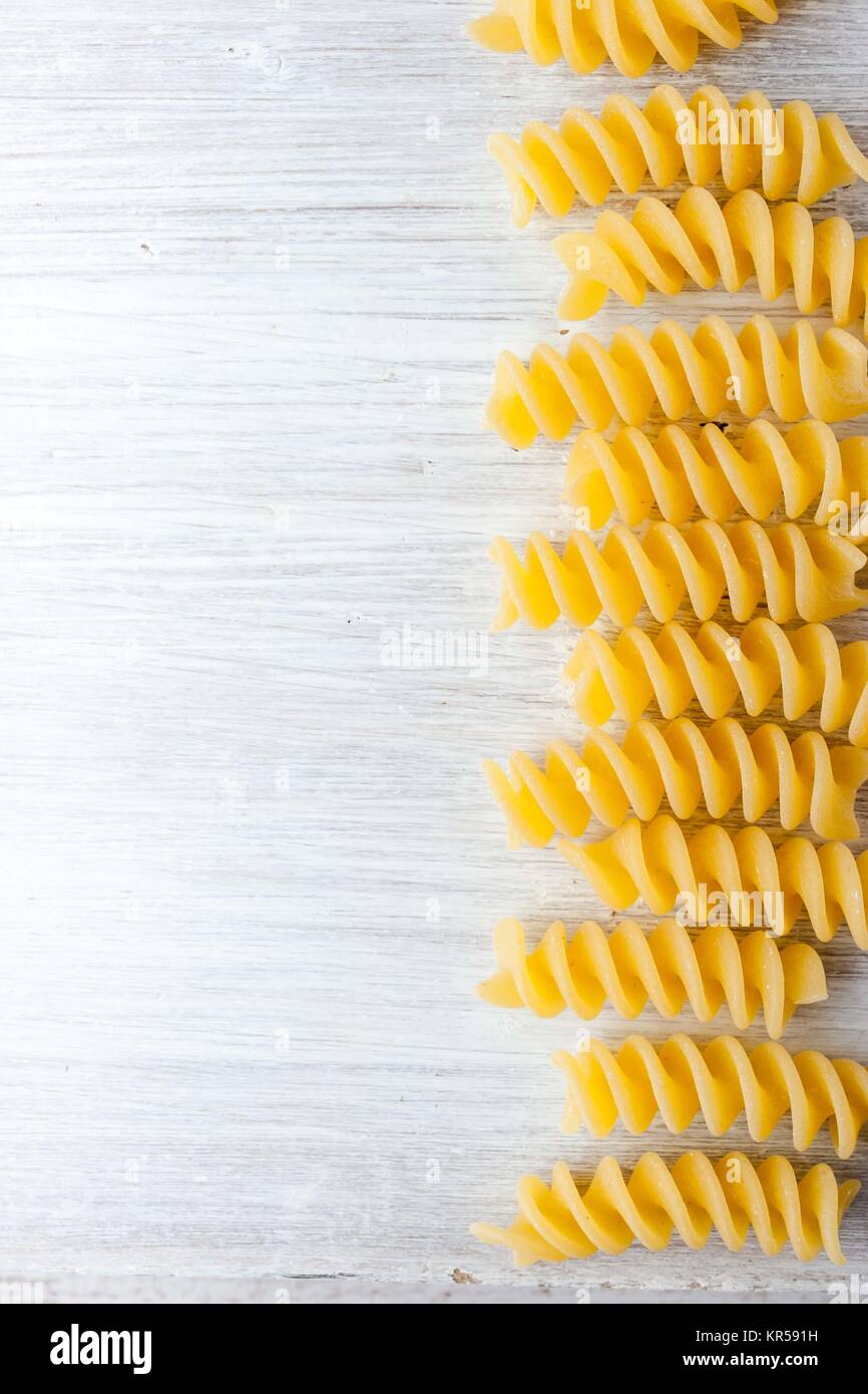 Pasta at the left of the white table vertical Stock Photo - Alamy